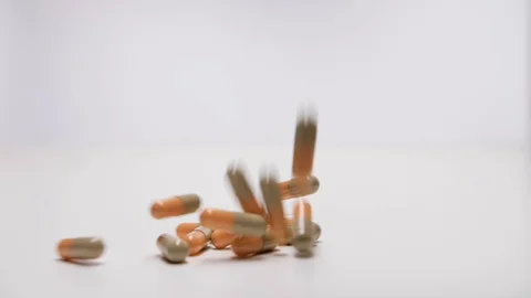 Medical capsules falling on white backgr... | Stock Video | Pond5