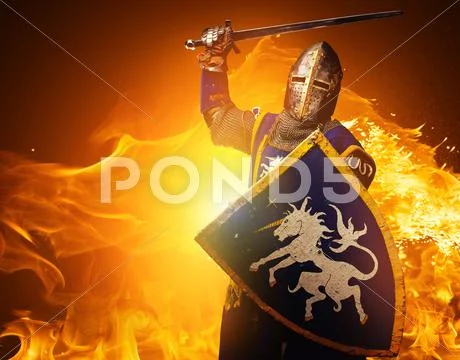 Medieval knight in attack position on fire background.: Royalty Free #40925798