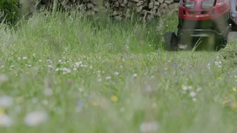Medium-Shot: Lawn tractor mowing lawn on... | Stock Video | Pond5