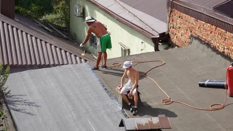 Men repairing the roof and covering it w... | Stock Video | Pond5