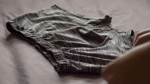 Men use their hands to fold men's underw... | Stock Video | Pond5