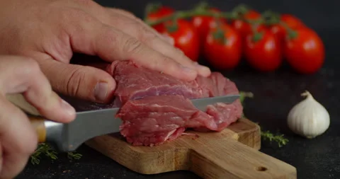 Men's hands cut beef into pieces. | Stock Video | Pond5