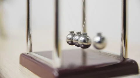 Metal balls of Newton cradle swing hangi... | Stock Video | Pond5