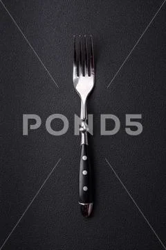 Metal kitchen fork on a dark textured concrete background ~ Hi Res ...