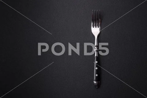 Metal kitchen fork on a dark textured concrete background ~ Hi Res ...