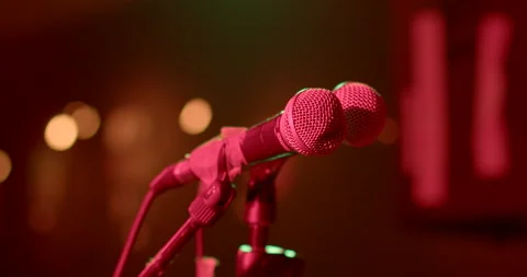 Microphones in red light on stage. They ... | Stock Video | Pond5