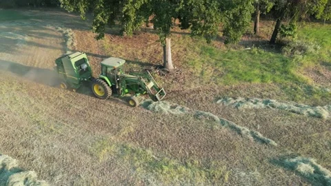 Mid altitude shot. John Deere tractor ba... | Stock Video | Pond5