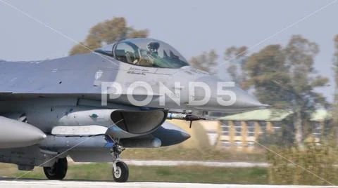 Military pilot with helmet in the cockpit of a NATO grey fighter jet ...