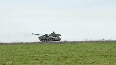 Military tank driving in the green field... | Stock Video | Pond5