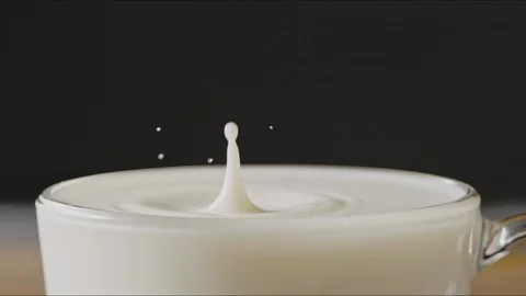Milk drops drip into a cup with organic ... | Stock Video | Pond5