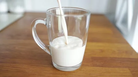 Milk in glass cup close-up. Glass with y... | Stock Video | Pond5