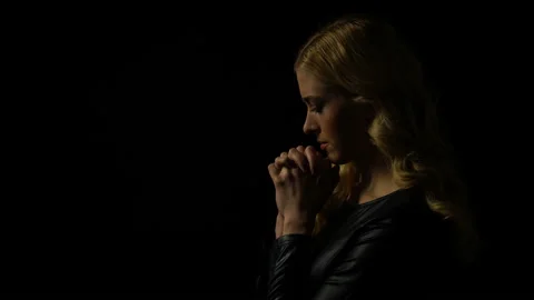 Miserable lady praying in darkness under... | Stock Video | Pond5
