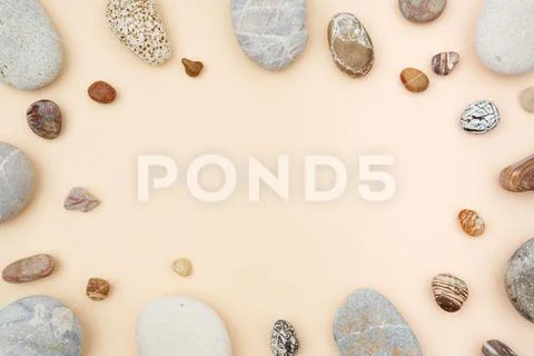Photograph: Mix of different sea stones on beige paper background ...
