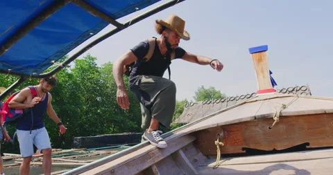 Mixed race friends jumping onto boat aft... | Stock Video | Pond5