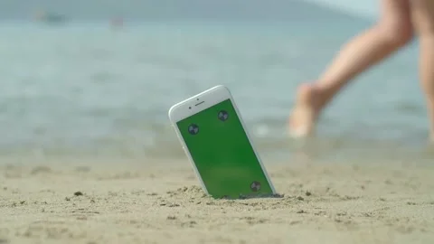 Mobile phone in sand at beach with green... | Stock Video | Pond5