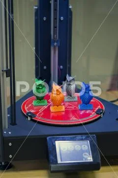 Models in the form of owls stand inside a three-axis 3d printer ...