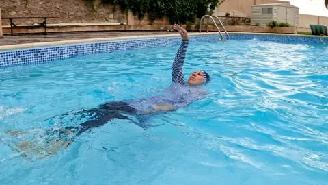 modern Muslim woman swimming in a pool | Stock Video | Pond5
