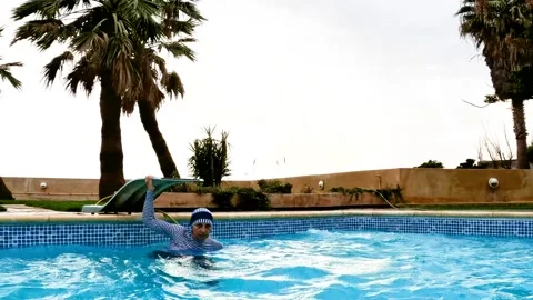 modern Muslim woman swimming in a pool | Stock Video | Pond5