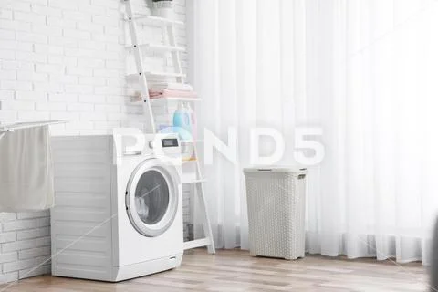 Modern washing machine near brick wall in laundry room interior, space ...
