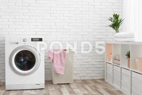 Modern washing machine near brick wall in laundry room interior, space ...