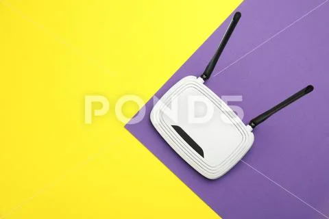 Modern Wi-Fi router on color background, top view. Space for text ...
