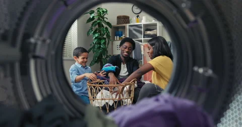 Mom and dad and son sort clothes sitting... | Stock Video | Pond5