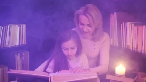 Mom and daughter sit together and read a... | Stock Video | Pond5