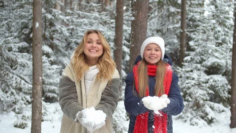 Mom and daughter throw snow over themsel... | Stock Video | Pond5