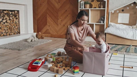 Mom Putting Toys In Box Together With Ba... | Stock Video | Pond5