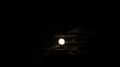 The moon is half hidden by the clouds, t... | Stock Video | Pond5