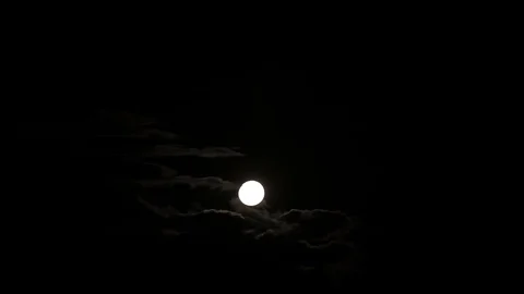 The moon is half hidden by the clouds, t... | Stock Video | Pond5