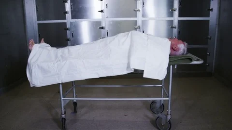 Morgue tilt up to elderly man on gurne... | Stock Video | Pond5
