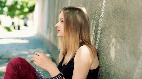 Morose, punk girl sitting on pathway and... | Stock Video | Pond5