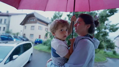 Mother and child son under umbrella duri... | Stock Video | Pond5