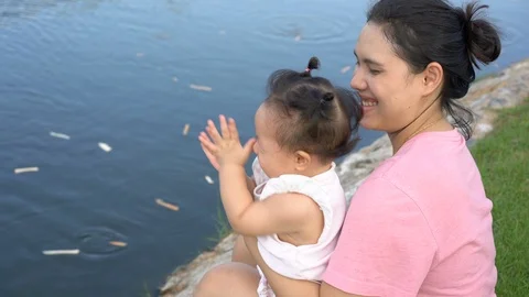 Mother and daughter feeding fish in the ... | Stock Video | Pond5