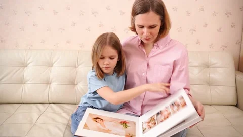 mother and daughter flip through a photo... | Stock Video | Pond5