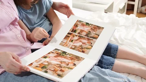 mother and daughter flip through a photo... | Stock Video | Pond5