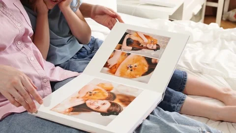 mother and daughter flip through a photo... | Stock Video | Pond5