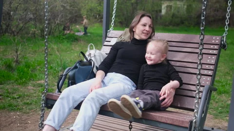 Mother and daughter ride a swing in the ... | Stock Video | Pond5