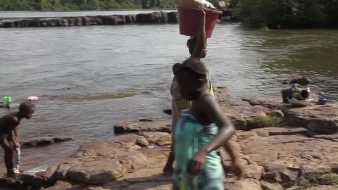 Mother with baby and bucket walking - Af... | Stock Video | Pond5