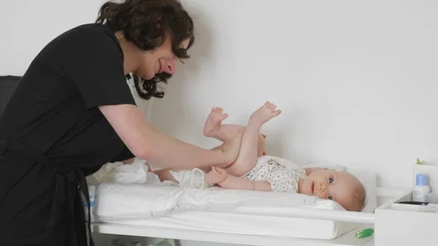 Mother with Baby on Diaper Change Mat | Stock Video | Pond5