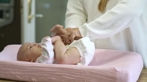 Mother changing baby daughter's nappy, p... | Stock Video | Pond5