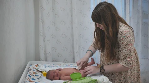 A mother changing her newborn baby girl'... | Stock Video | Pond5