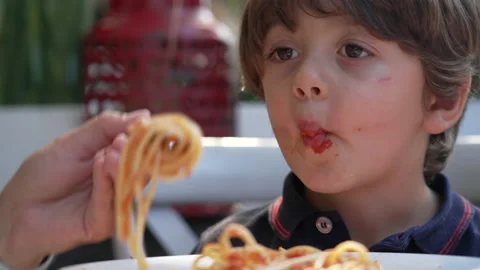 Mother feeding child spaghetti at lunch.... | Stock Video | Pond5