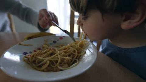 Mother feeding spaghetti pasta to child ... | Stock Video | Pond5