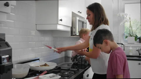 Mother multitasking in the kitchen with ... | Stock Video | Pond5