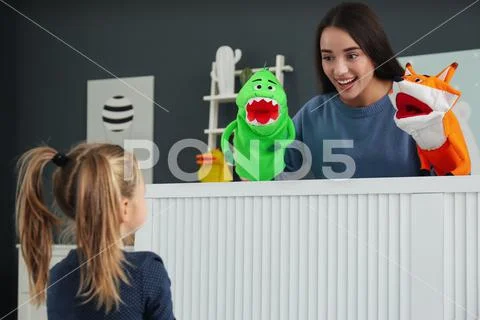 Mother performing puppet show for her daughter at home Stock Photo ...