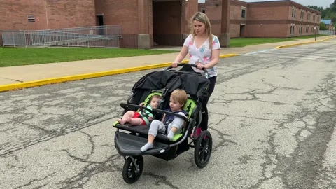 Mother pushing brother and sister in dou... | Stock Video | Pond5