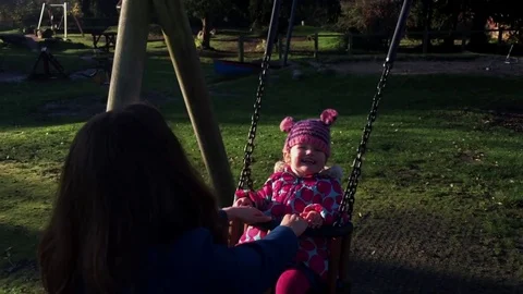 Mother pushing cute toddler daughter on ... | Stock Video | Pond5