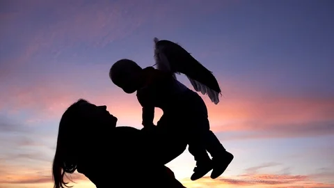 Mother silhouette rising up baby with an... | Stock Video | Pond5